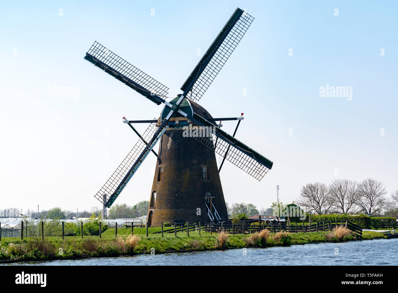Traditional Dutch wind mill built along canal in North Holland, spring ...