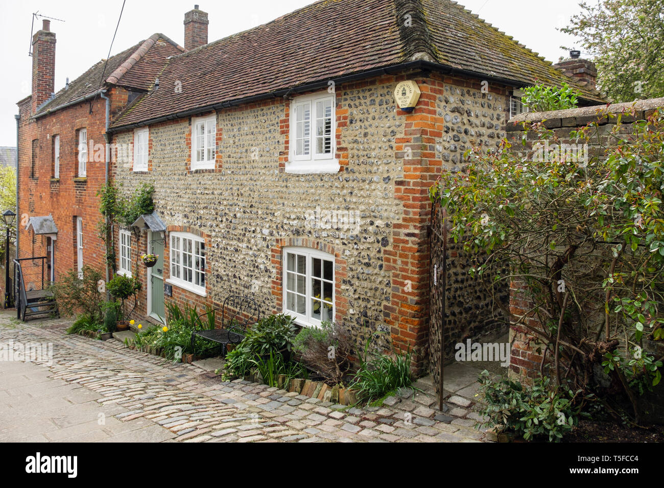 Old flint stone cottage on narrow steep street on a hill. Arundel, West ...