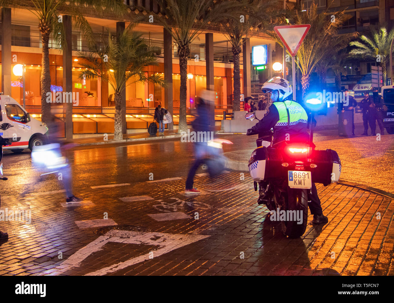 blue lights on police motorcyclist in wet street at night patrolling ...