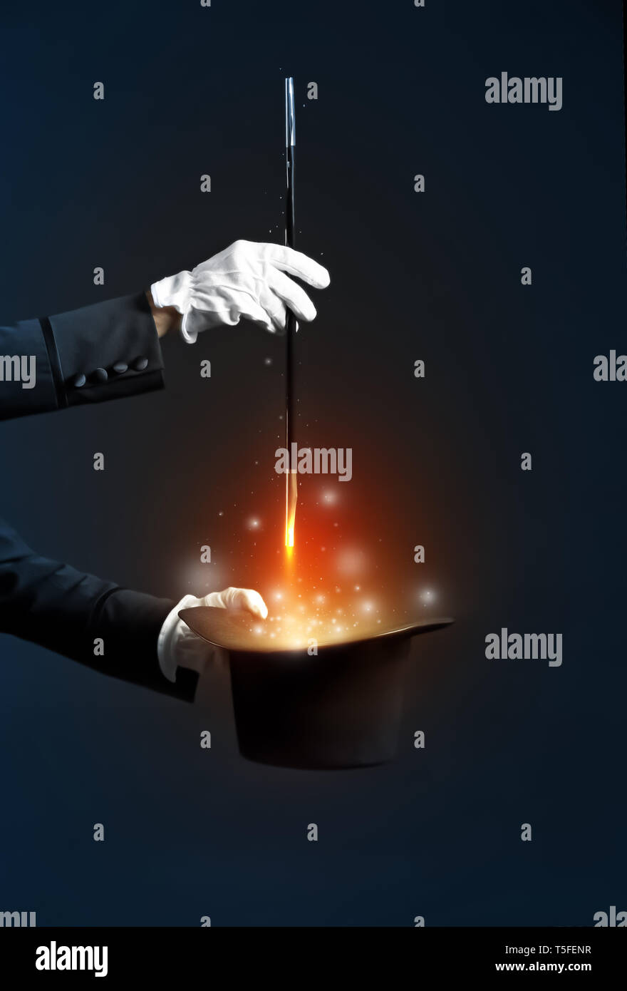 Magician showing trick with hat on dark background Stock Photo - Alamy