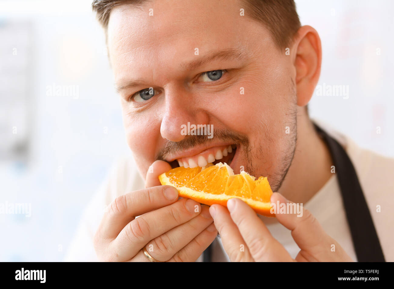 Professional Chef Bite Orange Slice Portrait Stock Photo - Alamy