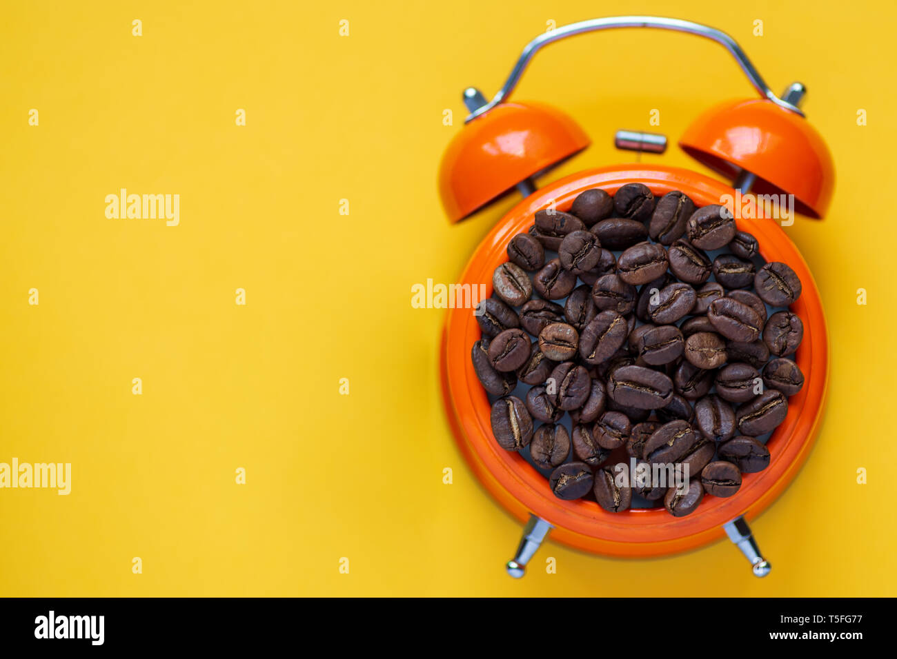 coffee beans in orange alarm clock on bright yellow background Stock ...