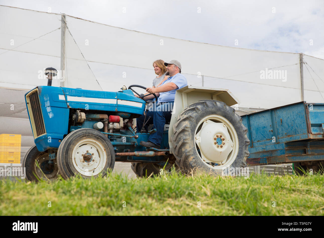 Farmer showing his daughter, how to drive a tractor Stock Photo - Alamy