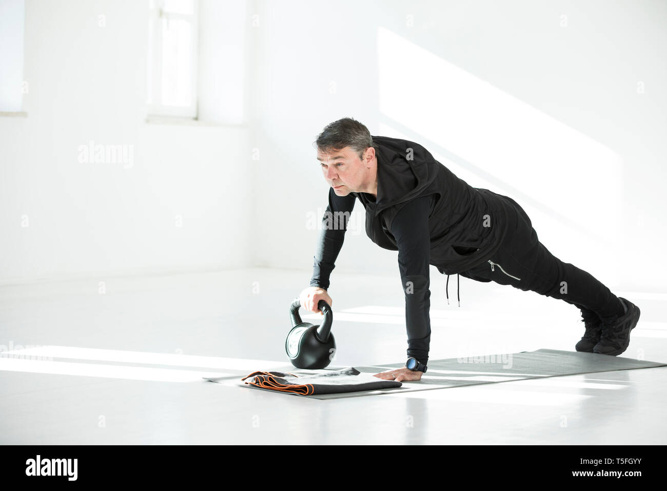 Man doing his fitness regime, doing kettle bell push-ups Stock Photo ...