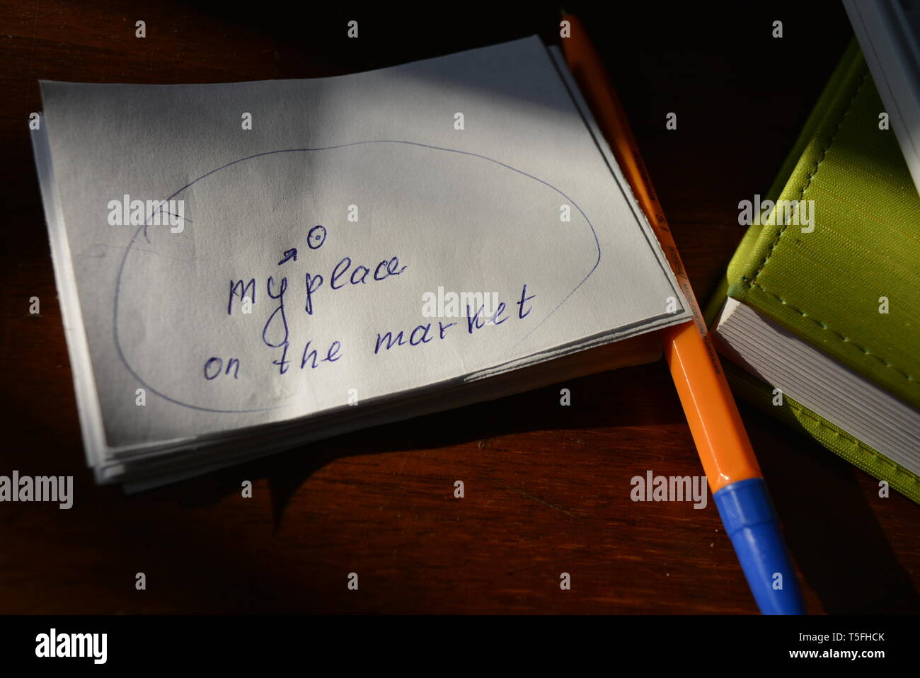 The inscription on paper is my place on the market and orange pen with ...