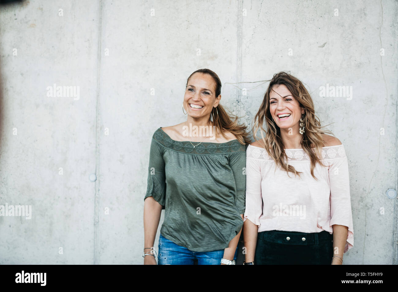 Portrait of two laughing friends standing side by side Stock Photo - Alamy
