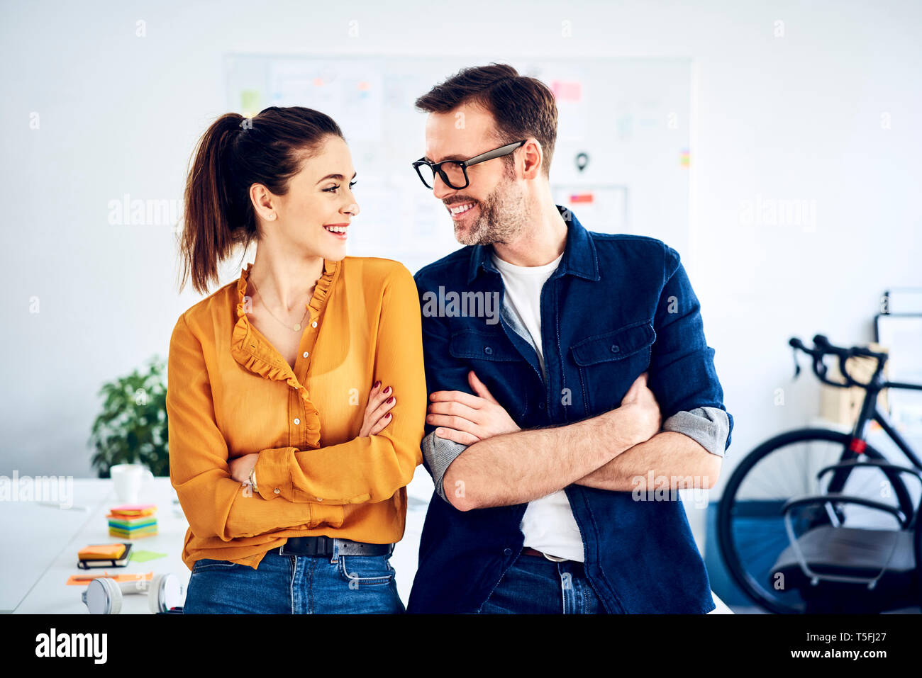 Two smiling colleagues in office facing each other Stock Photo - Alamy