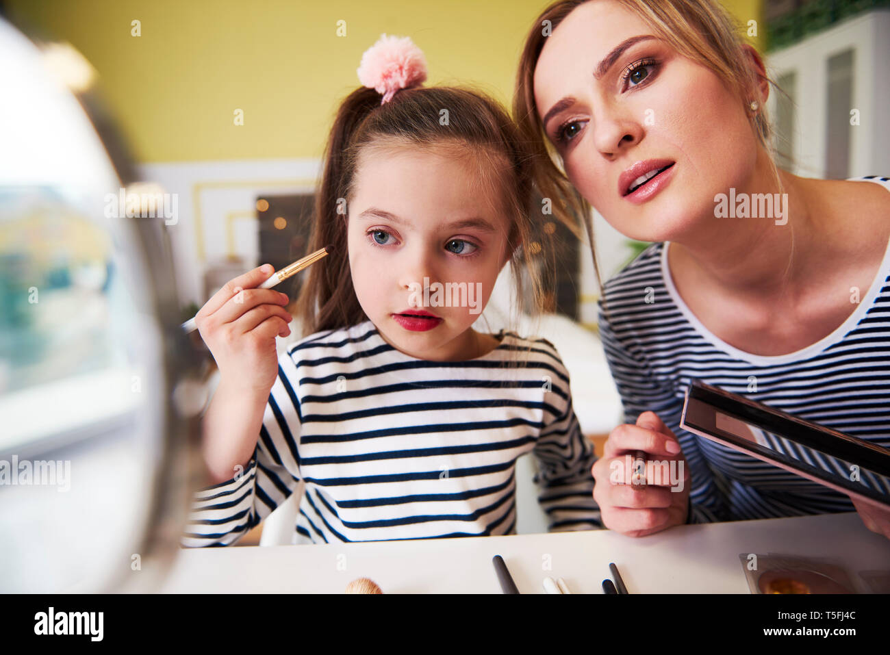 Mother and daughter applying make up together Stock Photo - Alamy