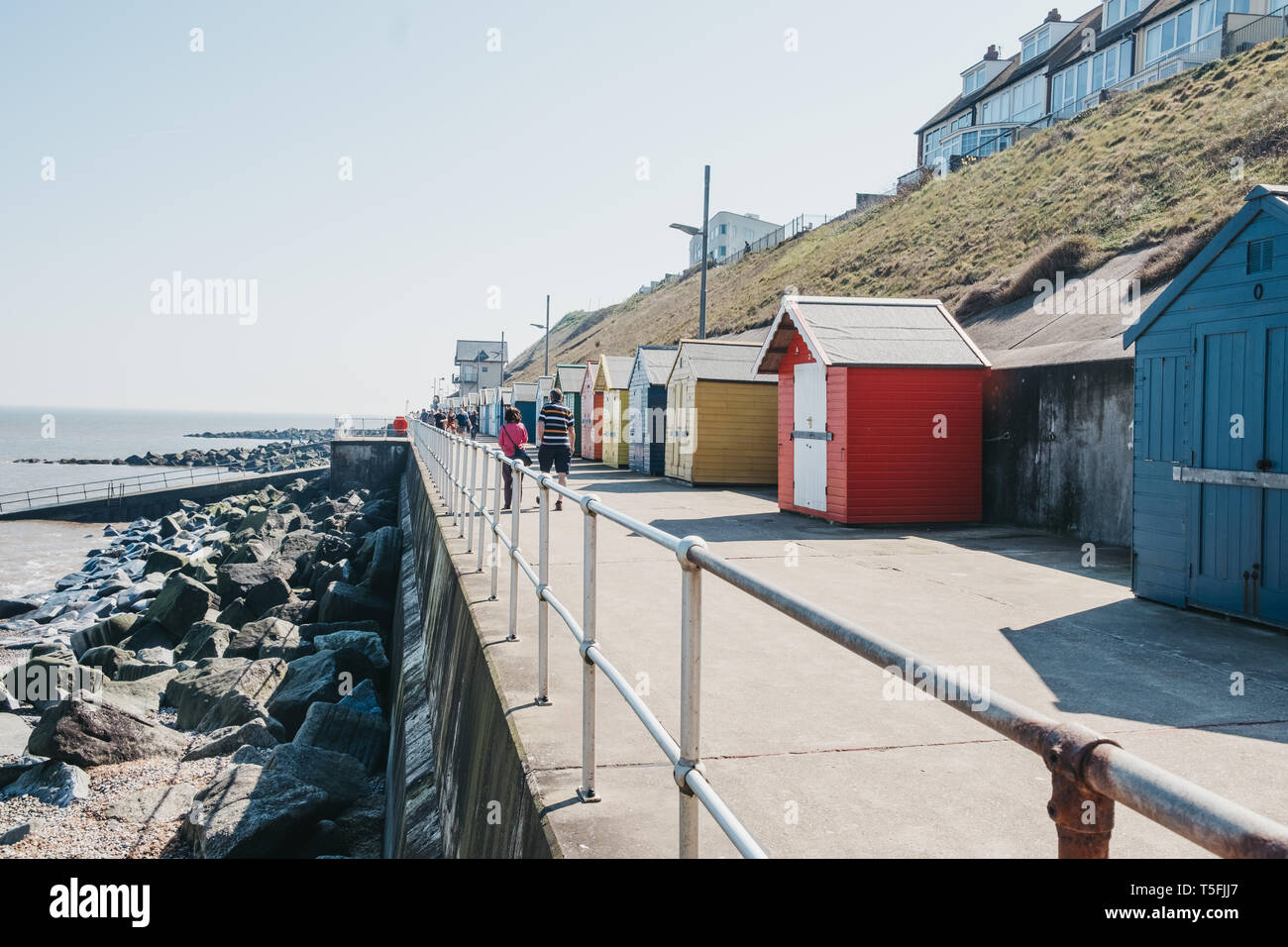 Sheringham, UK - April 21, 2019: People walking by colourful beach huts ...