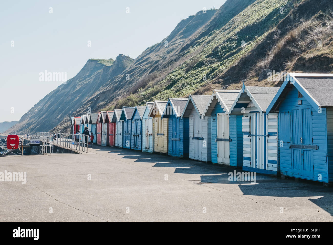 Sheringham, UK - April 21, 2019: People walking by colourful beach huts ...