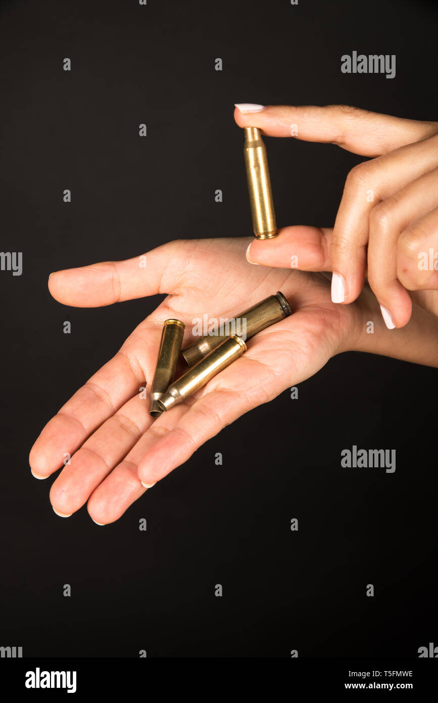 Female hand with bullet shells, a concept Stock Photo - Alamy