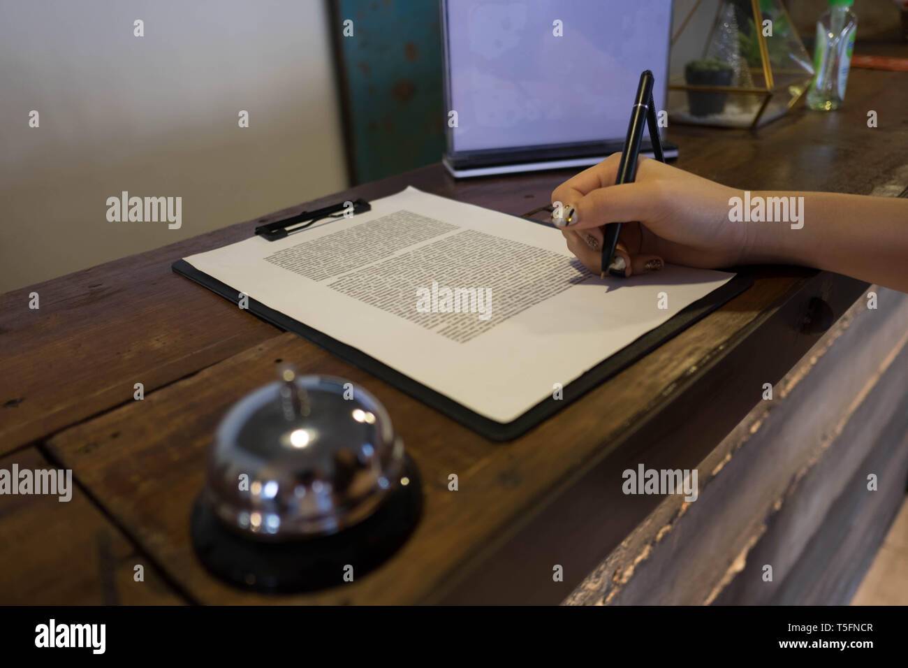 Close up of women putting signing and filling up form at hotel ...