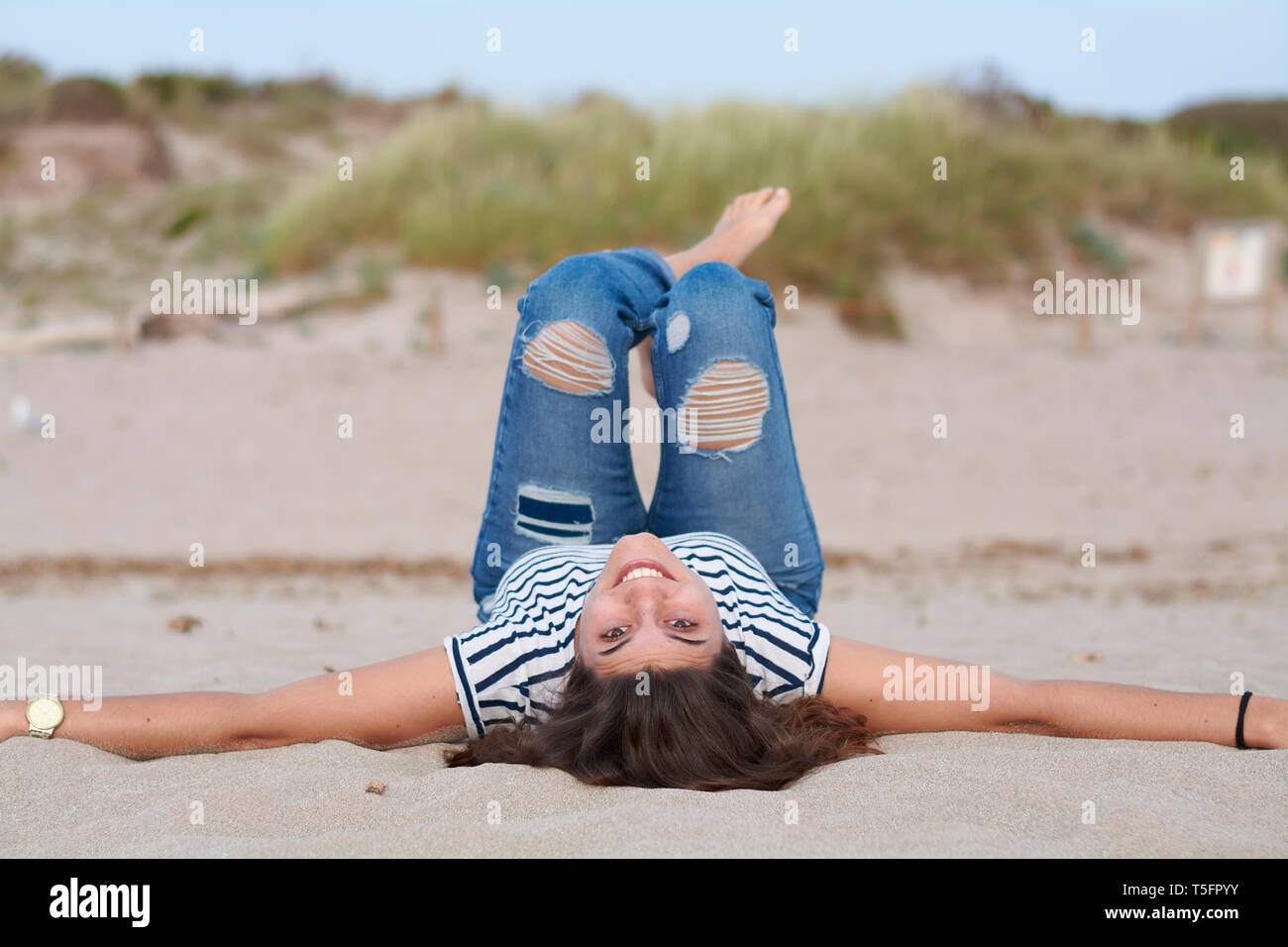 Portrait smiling young woman lying back beach hi-res stock photography ...