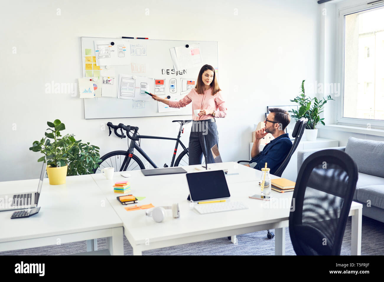 Two colleagues discussing at whiteboard in office Stock Photo - Alamy