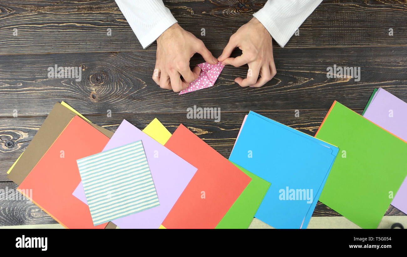 Male hands folding paper sheet Stock Photo - Alamy