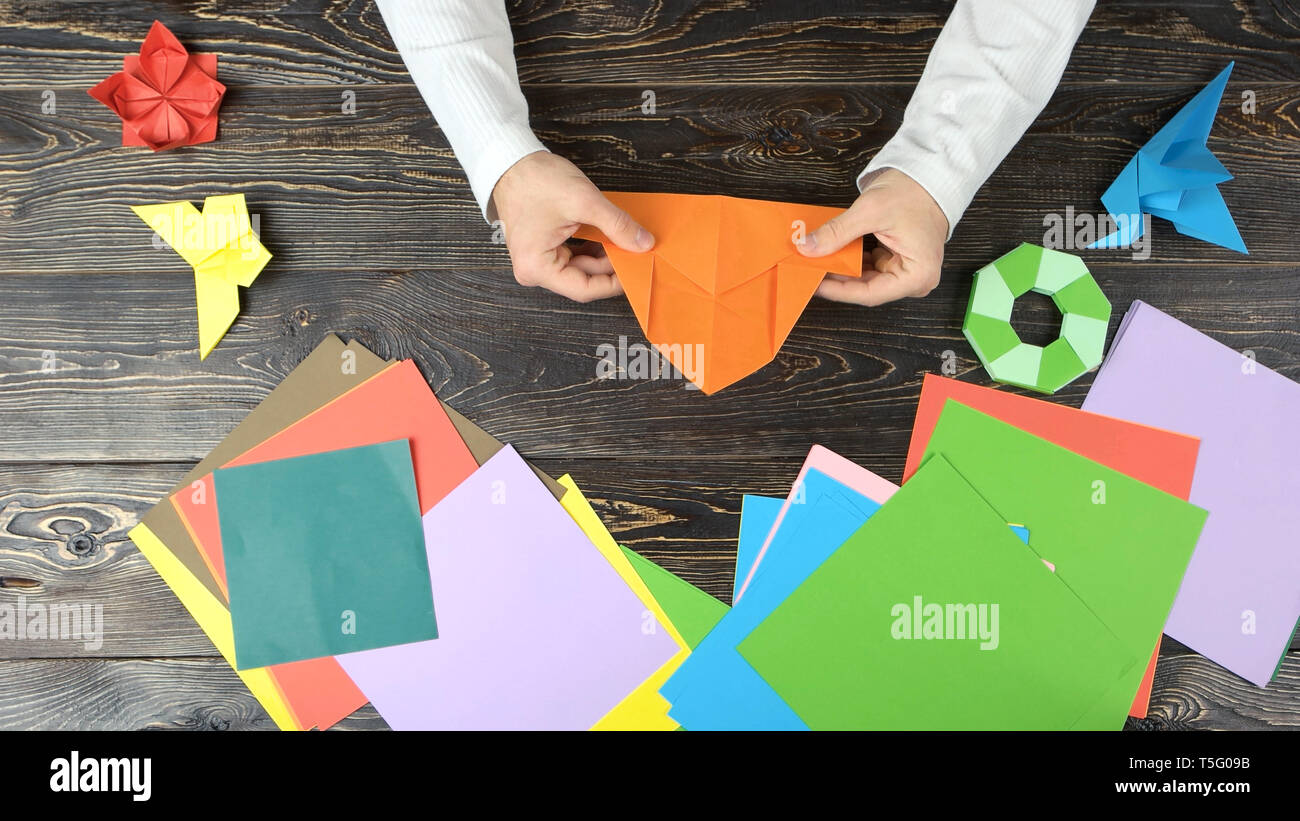 Hands fold sheet of paper to make figure Stock Photo - Alamy