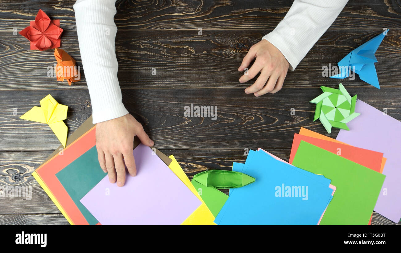Male hands making origami, top view Stock Photo - Alamy