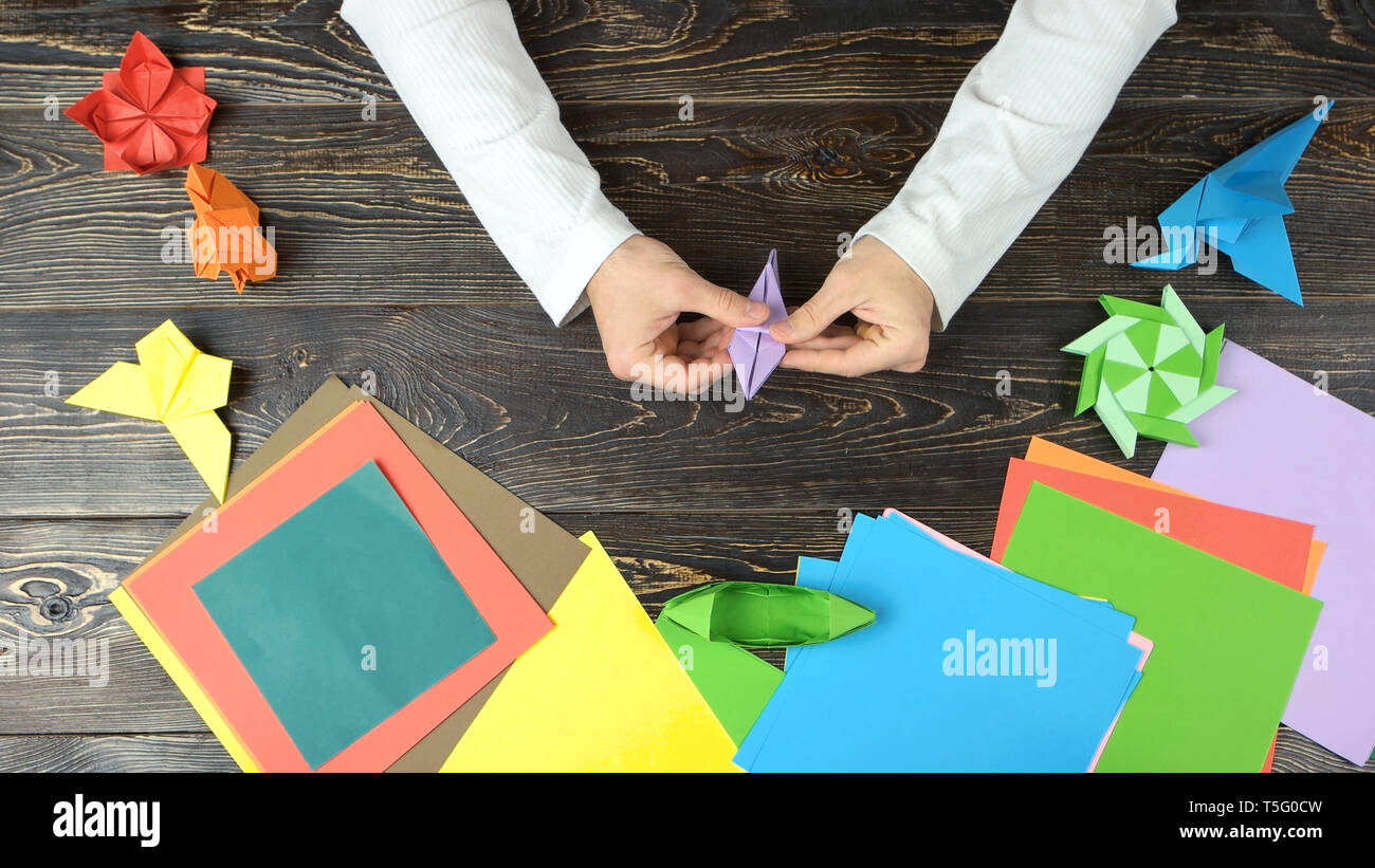 Mans hands doing origami flower Stock Photo - Alamy