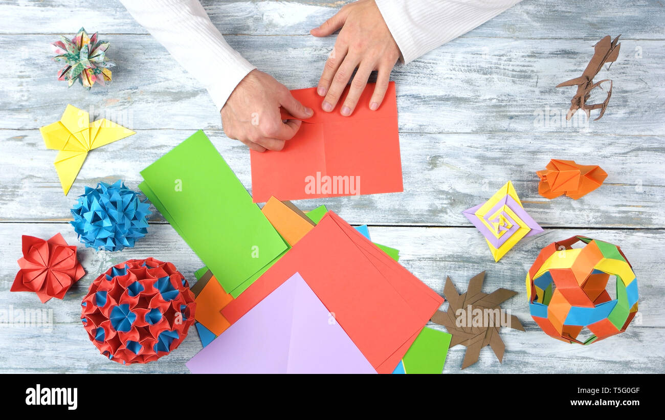 Person folding red paper sheet Stock Photo - Alamy