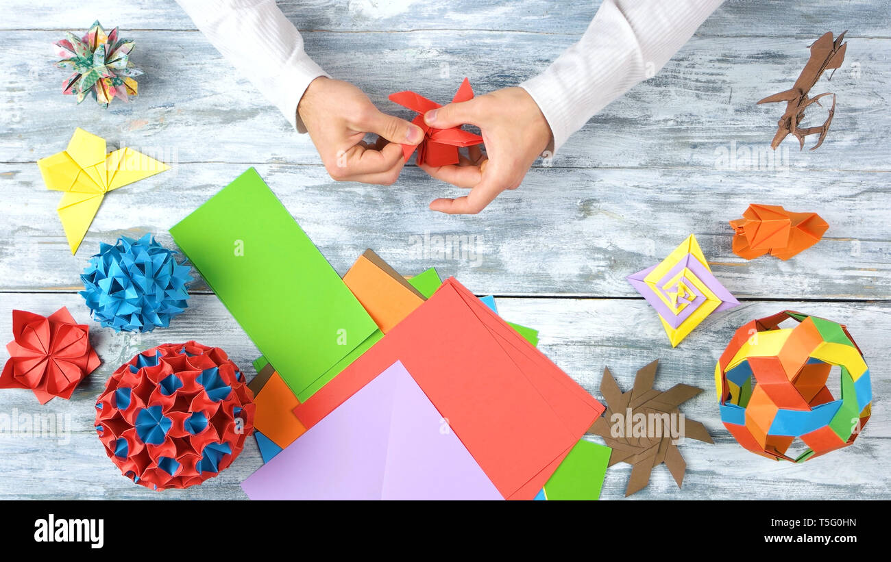Hands folding origami tulip, top view Stock Photo - Alamy