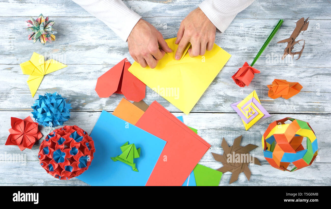 Person folding yellow paper sheet Stock Photo - Alamy