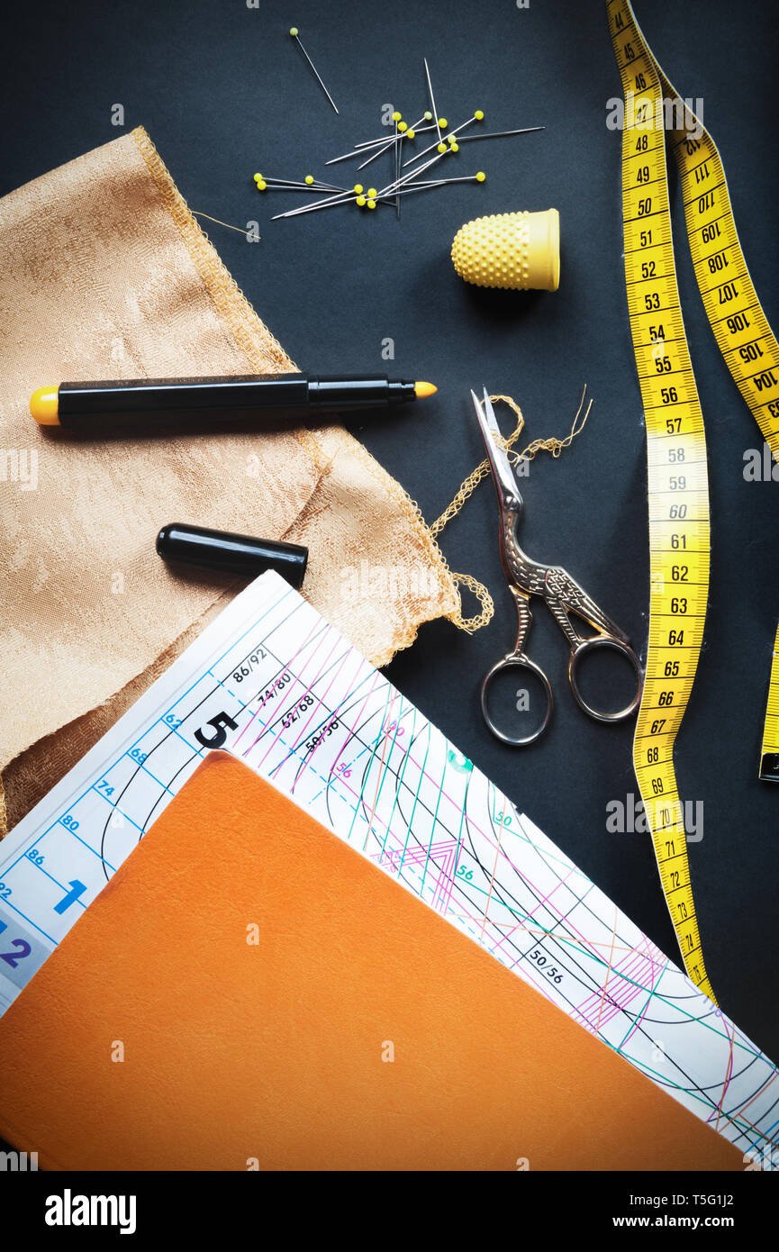 sewing tools thread with scissors and measuring tape on dark Stock ...