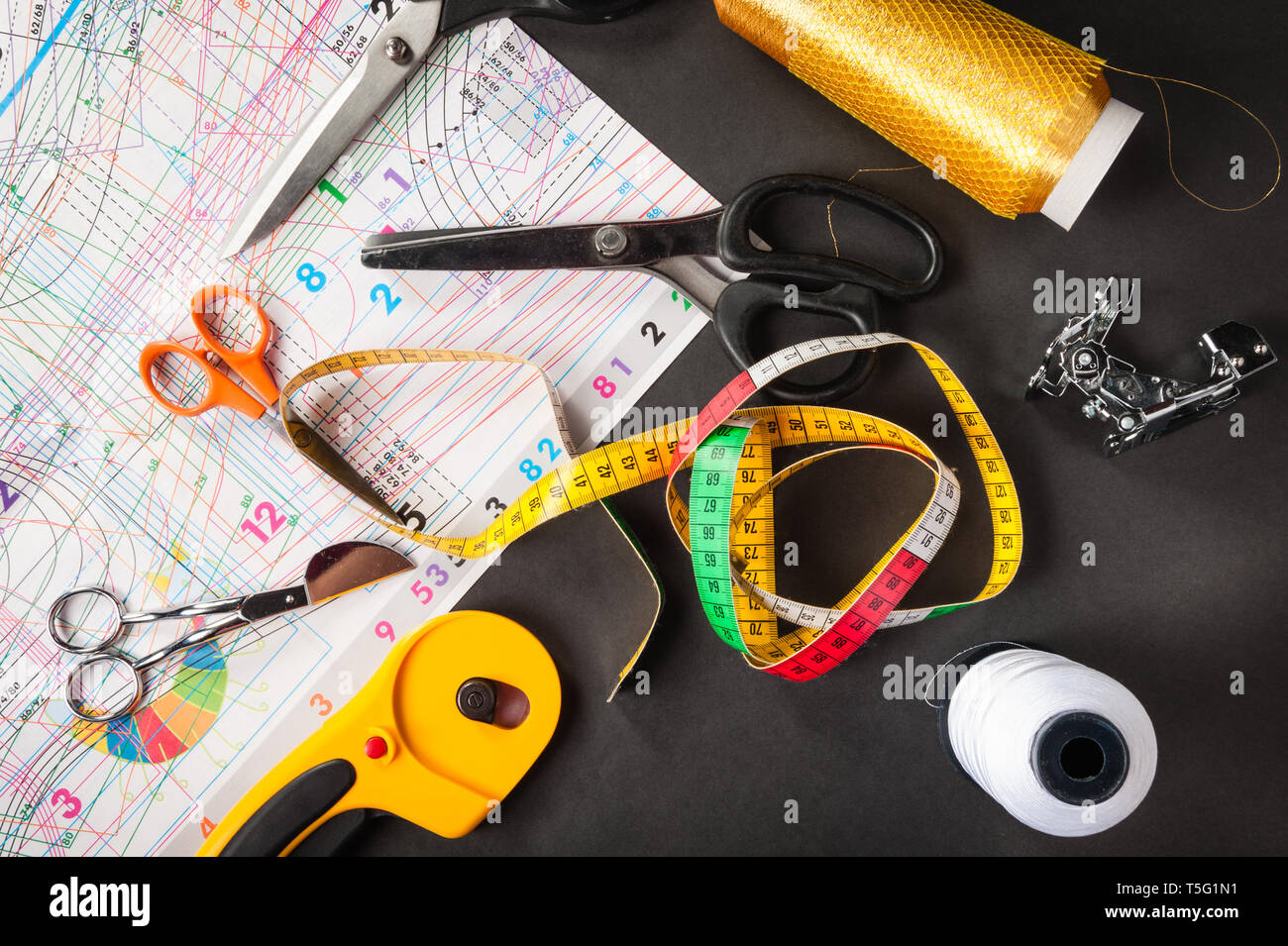 sewing tools thread with scissors and measuring tape on dark Stock ...