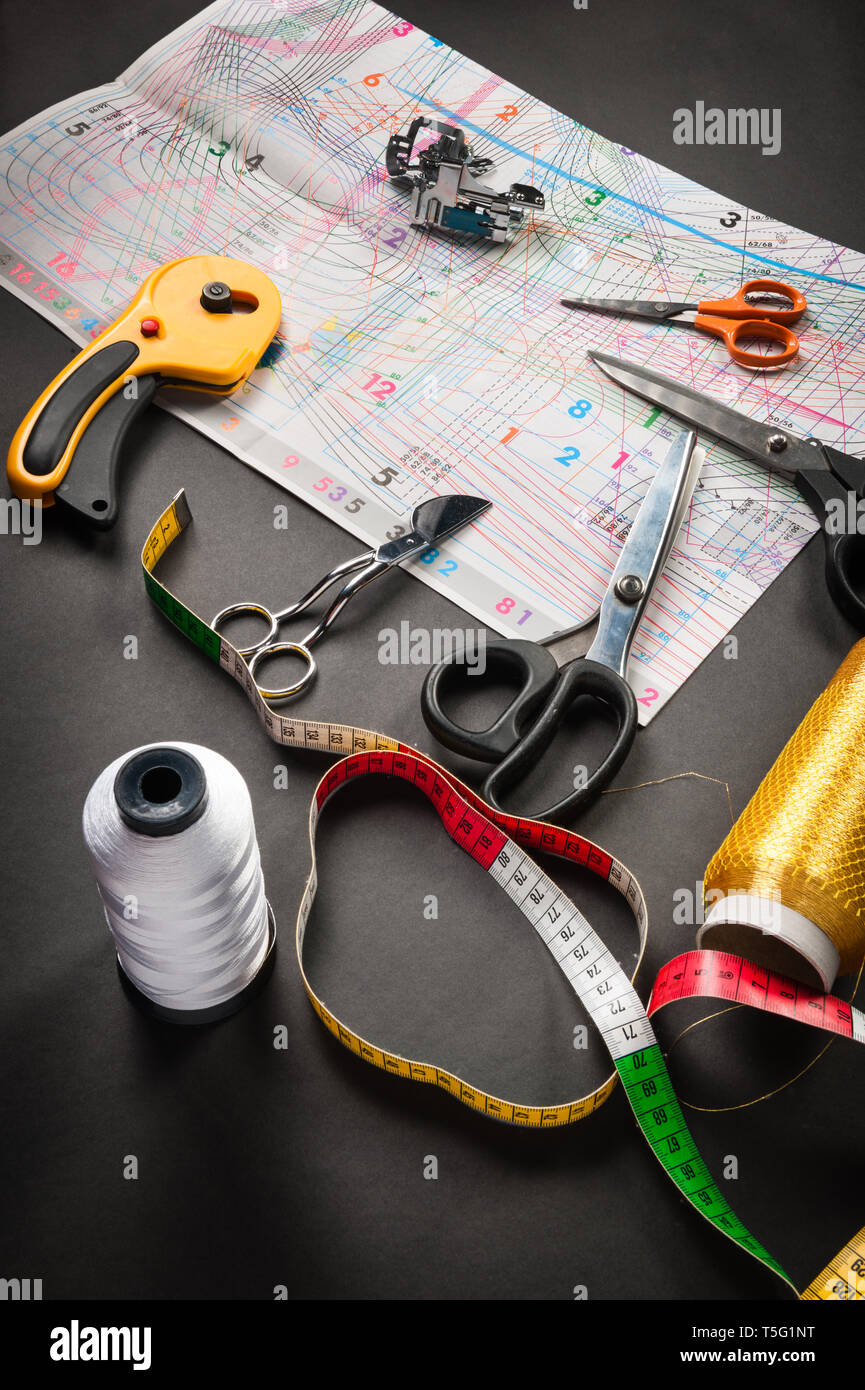 sewing tools thread with scissors and measuring tape on dark Stock ...
