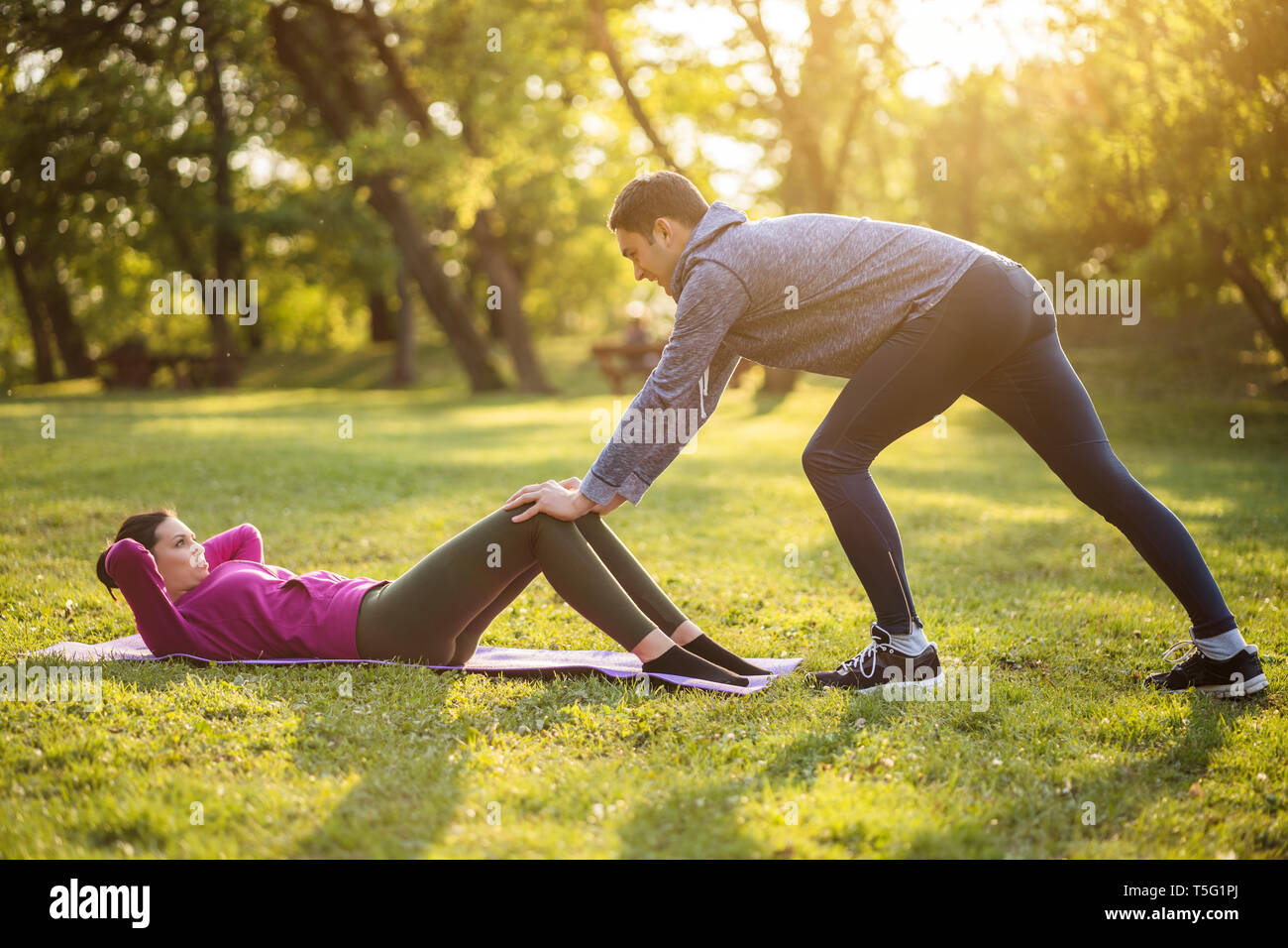 Physical therapist is showing exercises for sciatica recovery to young ...