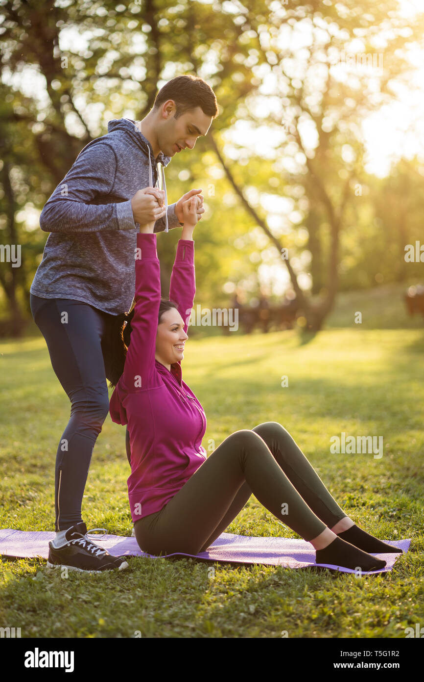 Physical therapist is showing exercises for sciatica recovery to young ...