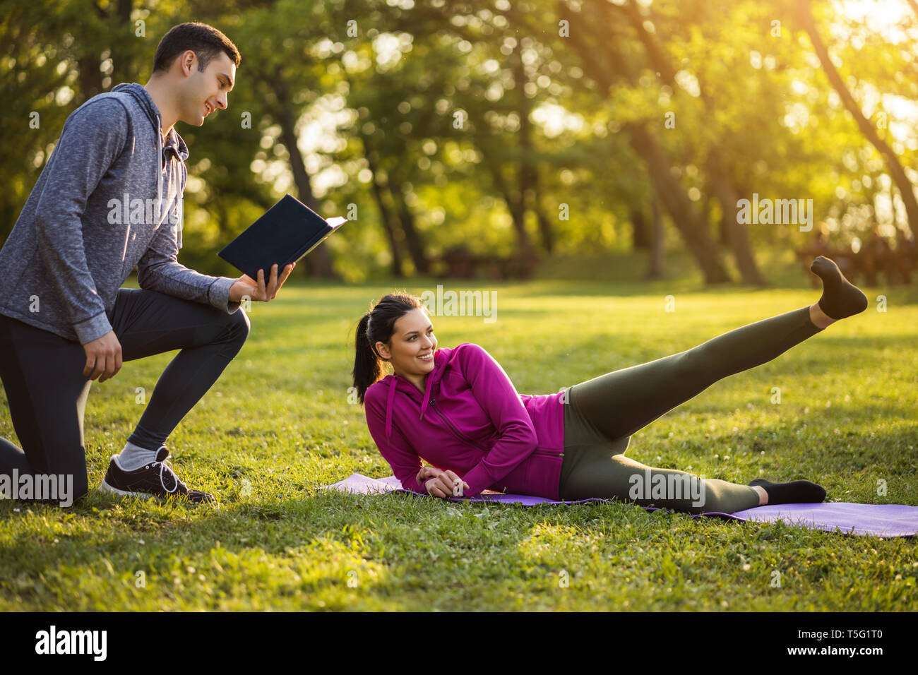 Physical therapist is showing exercises for sciatica recovery to young ...