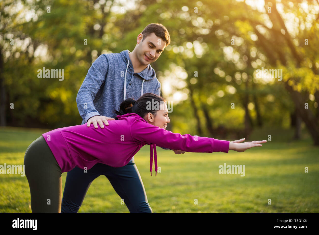 Physical therapist is showing exercises for sciatica recovery to young ...