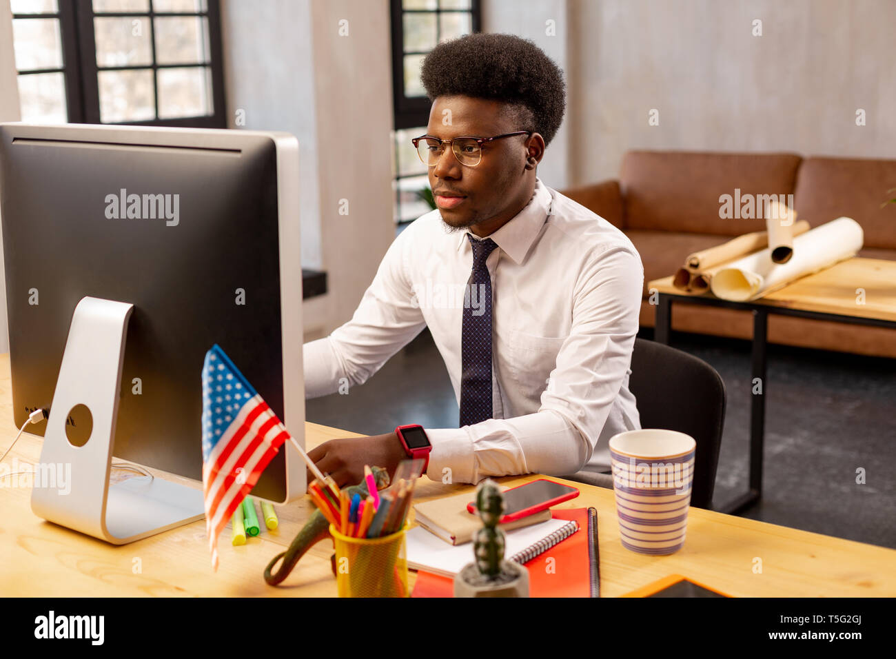 Serious young man looking at the computer screen Stock Photo - Alamy