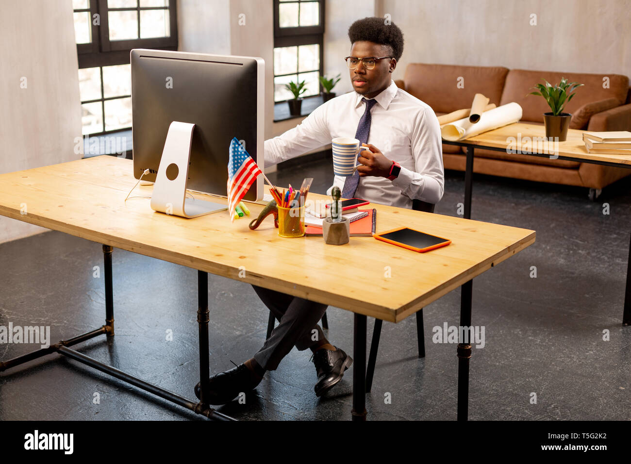 Serious African American man having tea at work Stock Photo - Alamy
