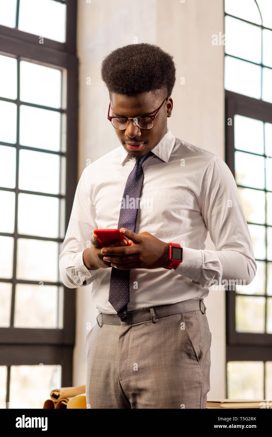 Handsome young man looking at his smartphone screen Stock Photo - Alamy