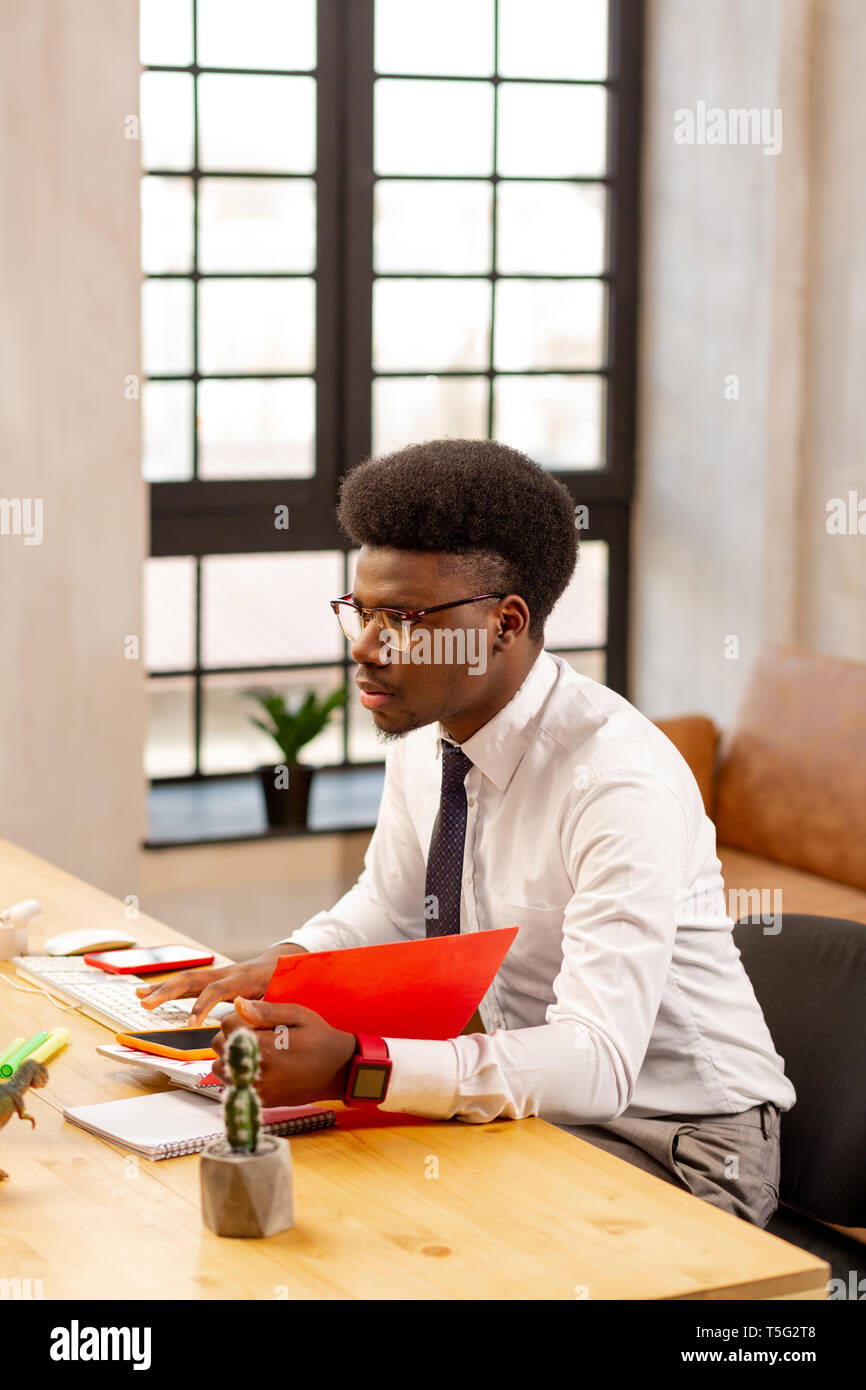 Nice smart man sitting at the office desk Stock Photo - Alamy
