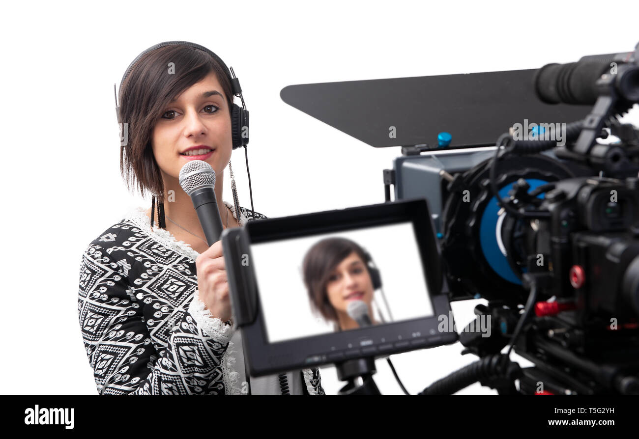 a pretty young woman journalist presenting report in television studio ...