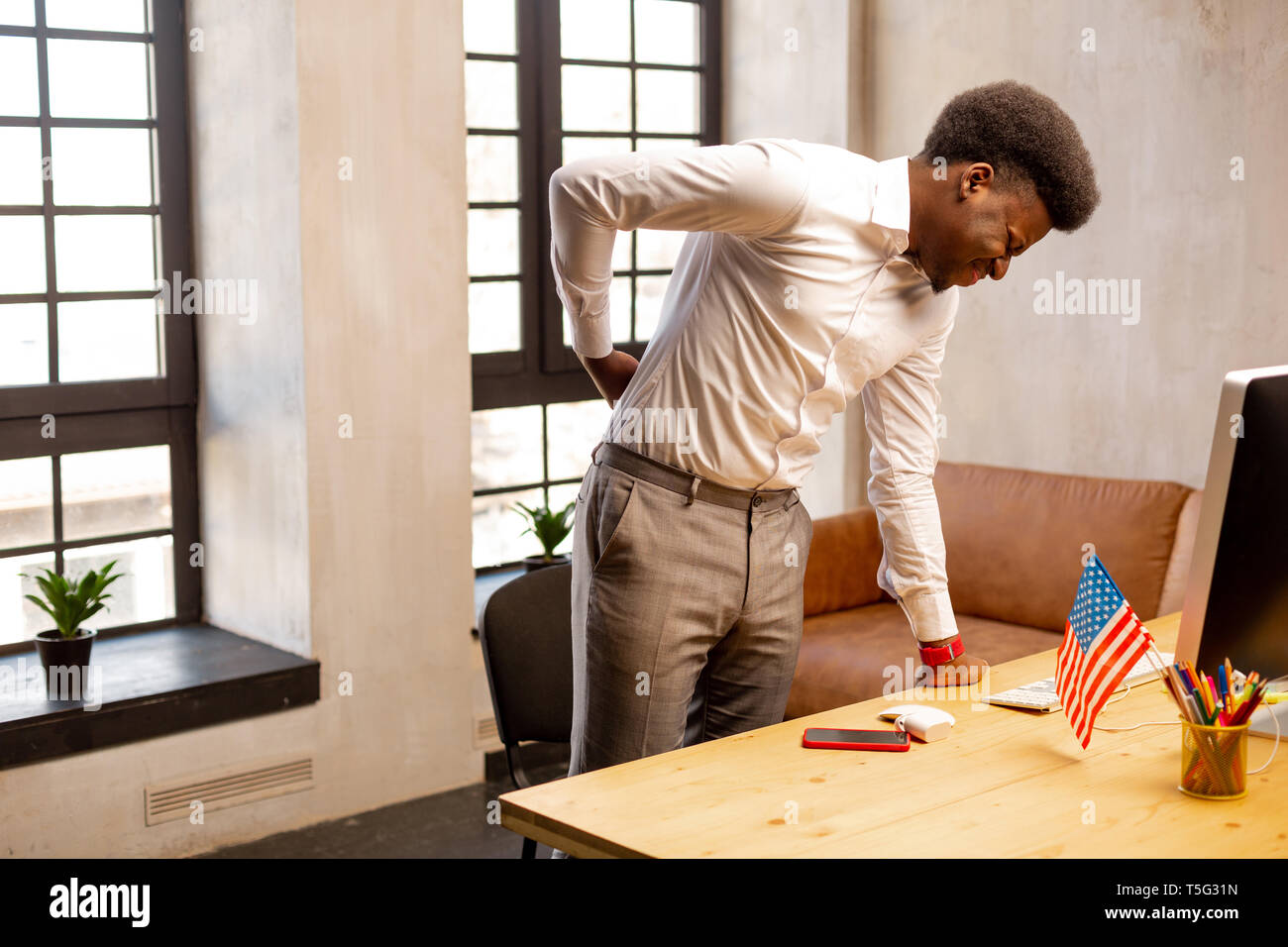 Sad young man standing near the table Stock Photo - Alamy