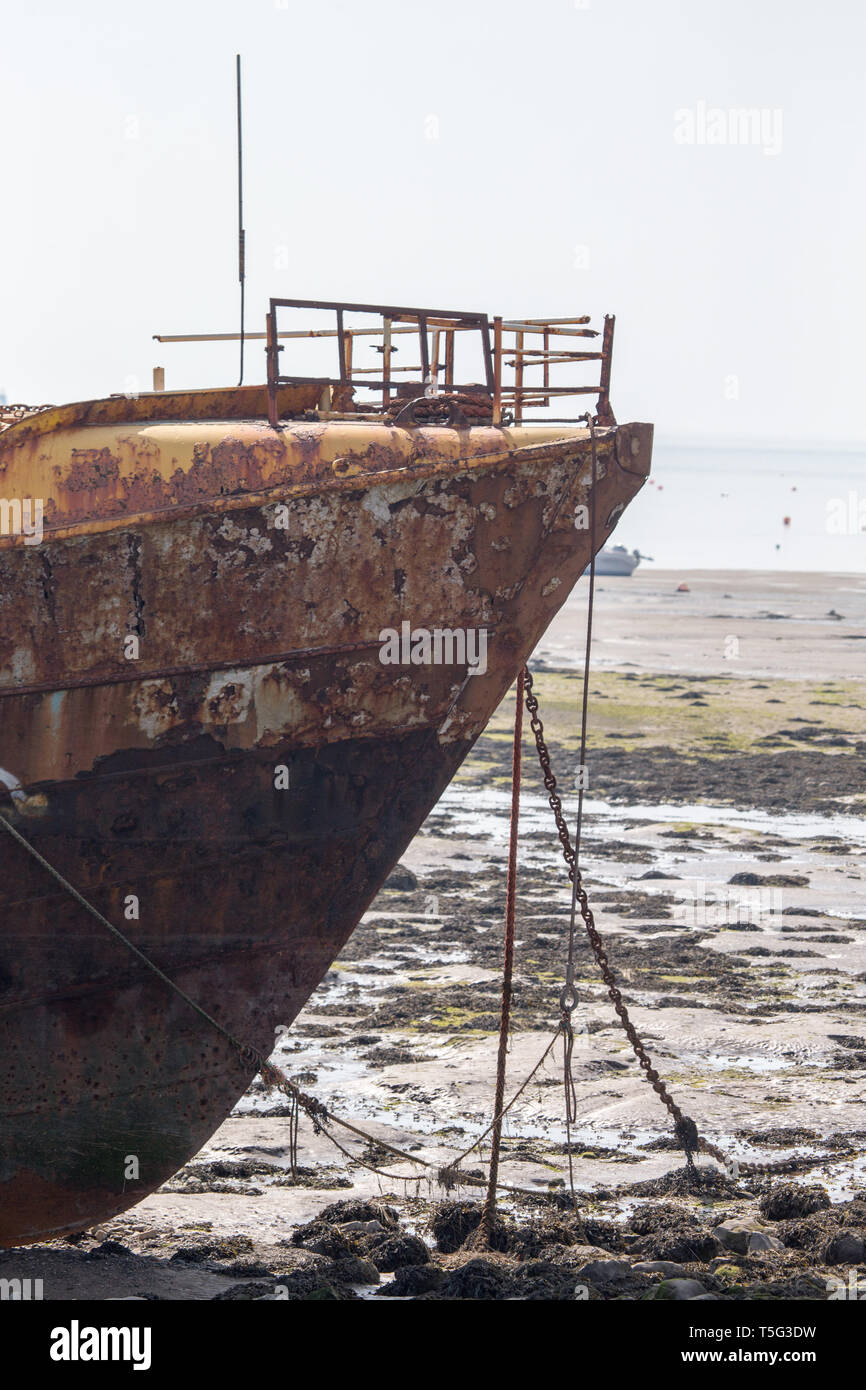 A ship wrecked fishing boat aground and abandoned rusting away on the shore line at Rampside in ...