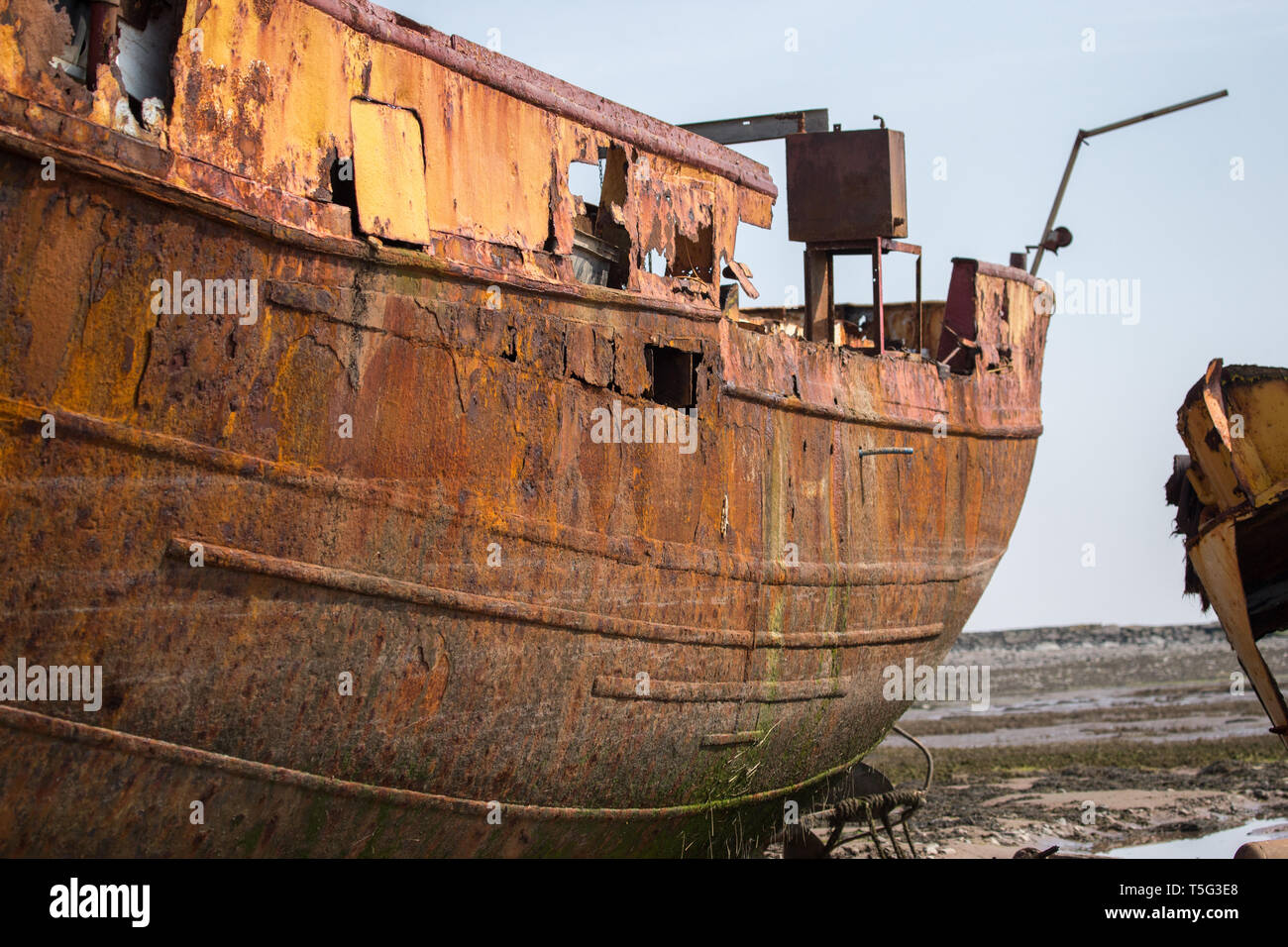 A ship wrecked fishing boat aground and abandoned rusting away on the ...