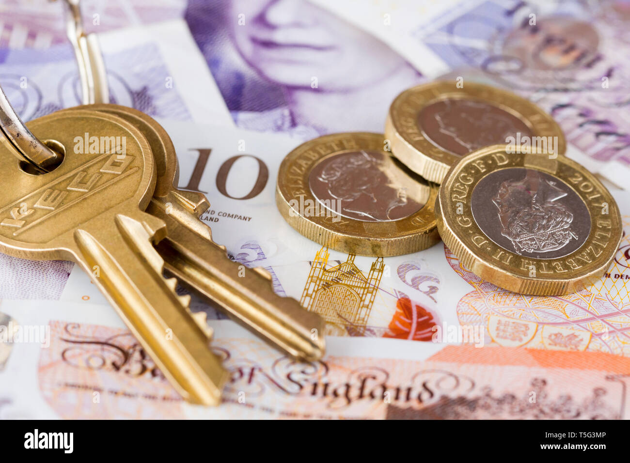 House keys & British sterling notes & coins. Financial concept. United ...