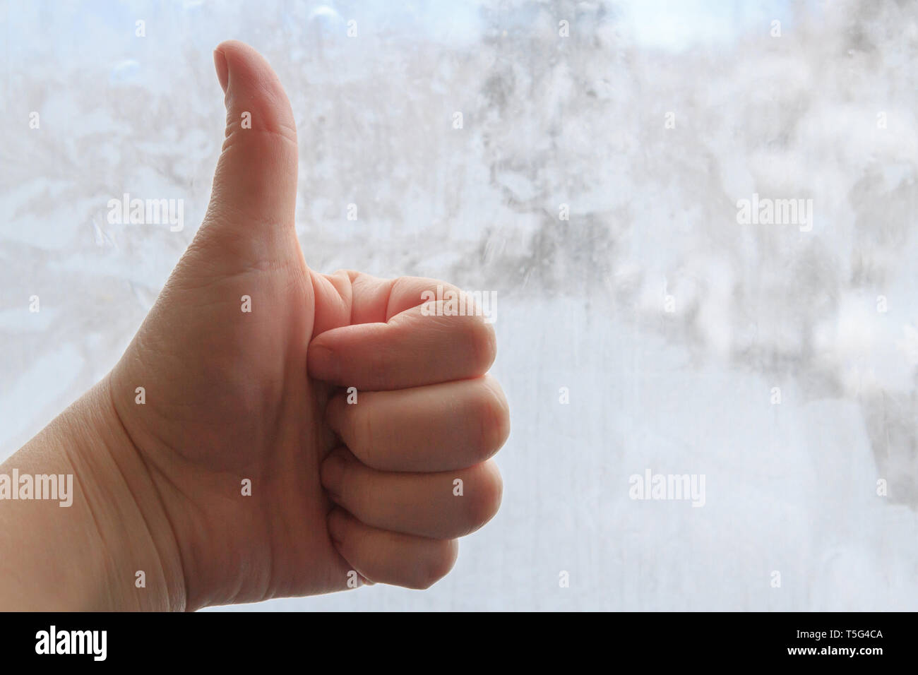 Sign of thumb up hand in front of a frozen window Stock Photo - Alamy