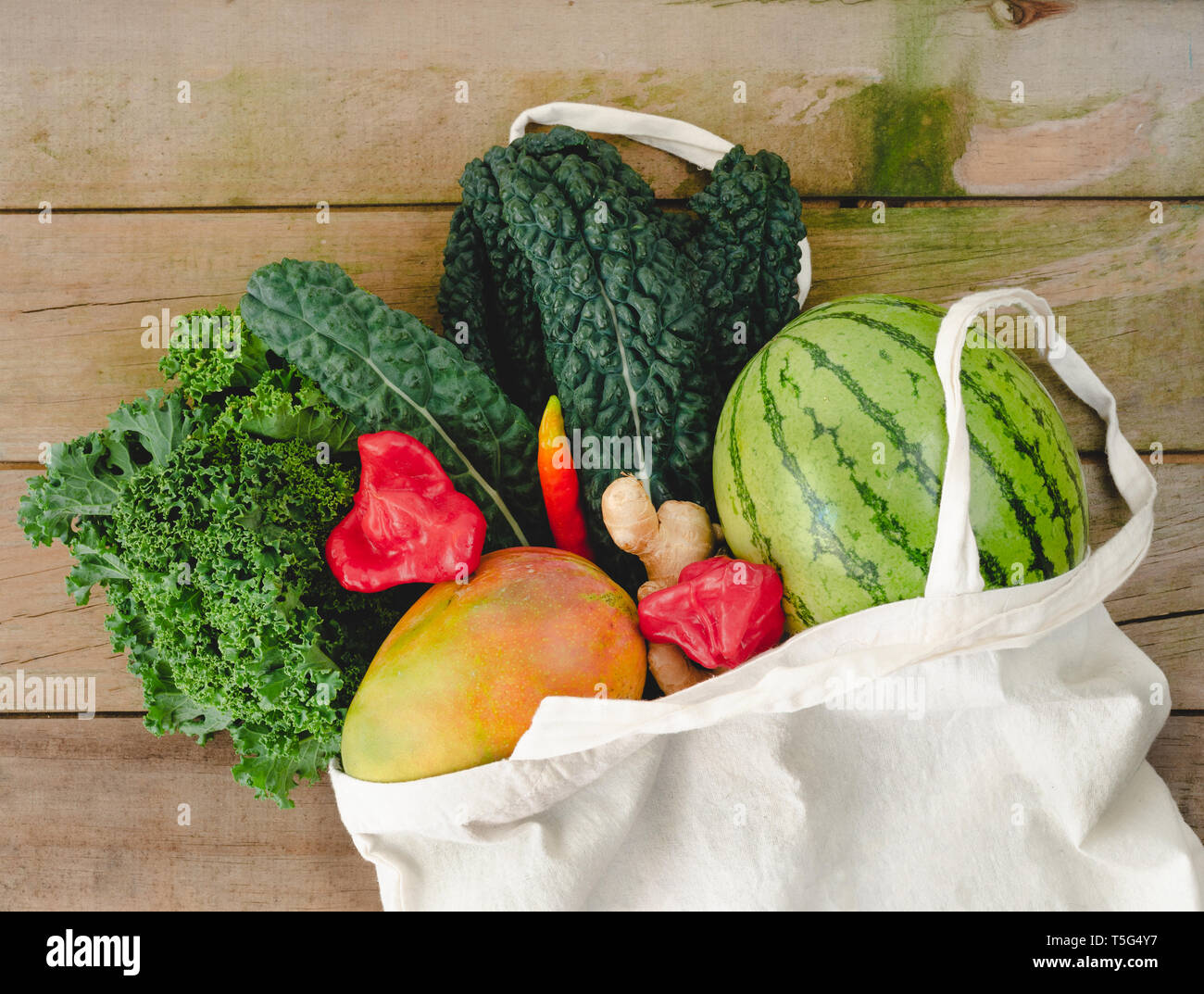 Ecological cloth bag with vegetables on rustic wooden background. Top ...