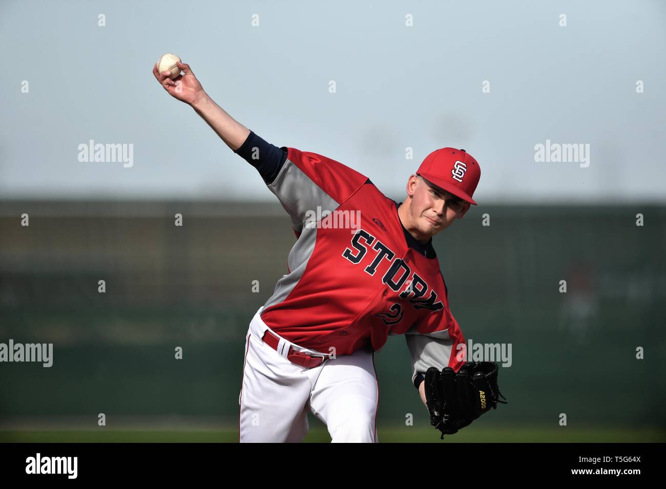 On the mound, a pitcher releasing a pitch to a waiting hitter. USA ...
