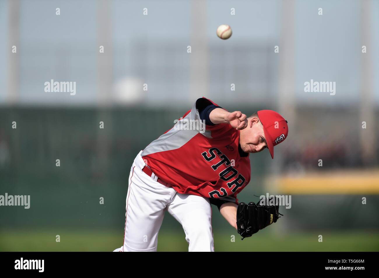 On the mound, a pitcher releasing a pitch to a waiting hitter. USA ...