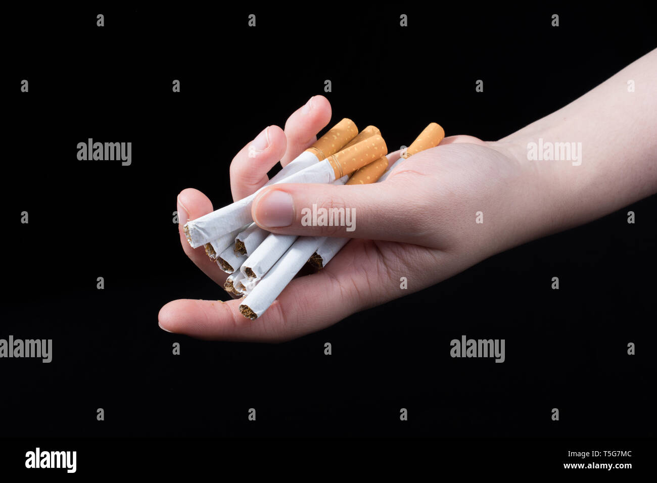 Hand is giving out cigarettes on a black background Stock Photo - Alamy