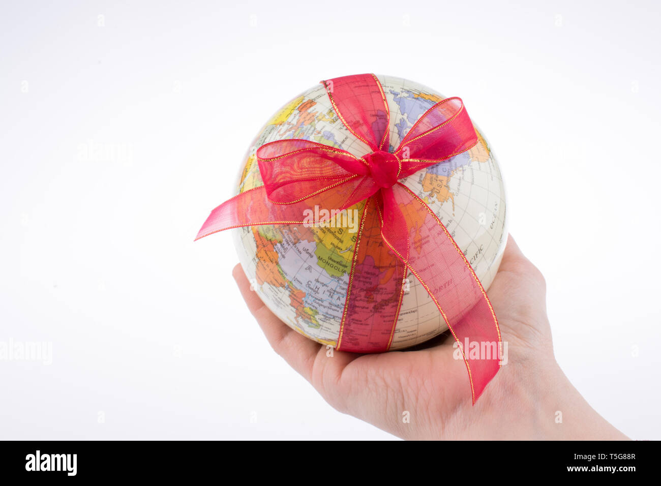 Globe tied with red ribbon on a white background Stock Photo - Alamy