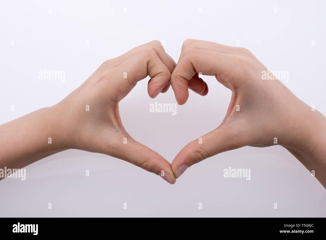 Hand making a heart shape on a white background Stock Photo - Alamy