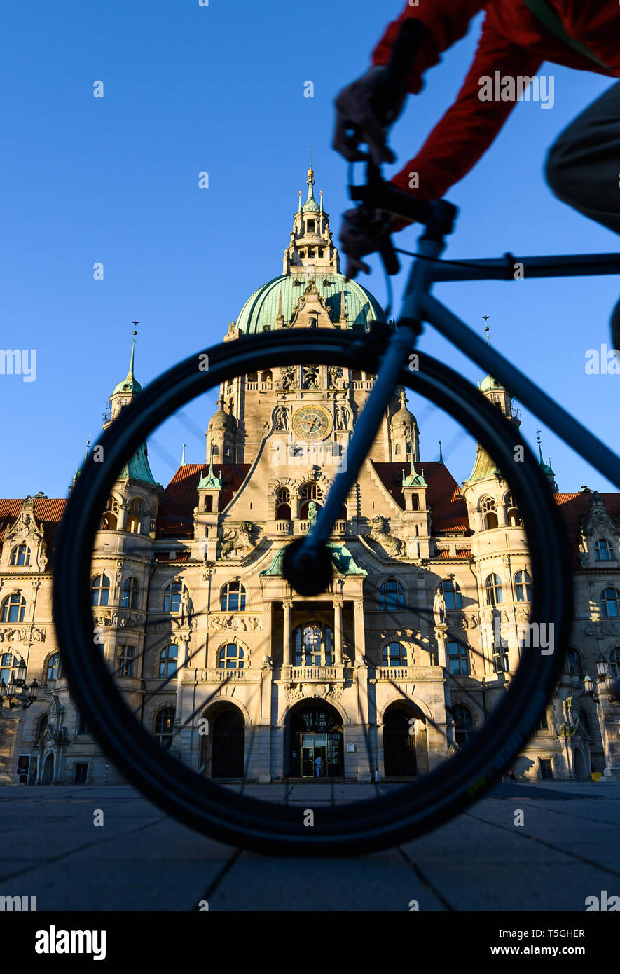 Hannover, Germany. 25th Apr, 2019. A cyclist drives past the town hall ...