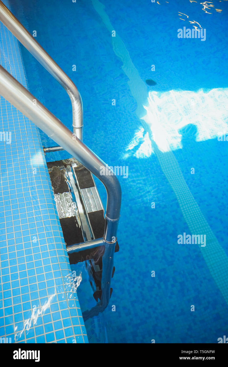 Metal swimming pool steps.Vertical image Stock Photo - Alamy